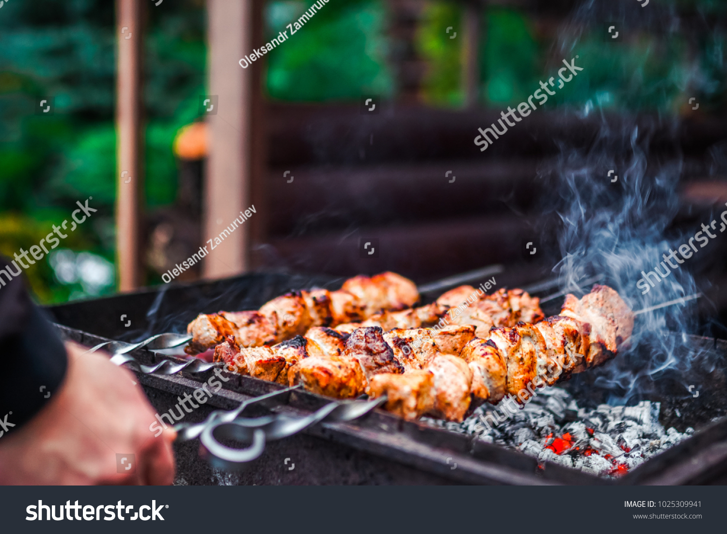 Grilled kebab cooking on metal skewer. Roasted meat cooked at barbecue. BBQ fresh beef meat chop ...