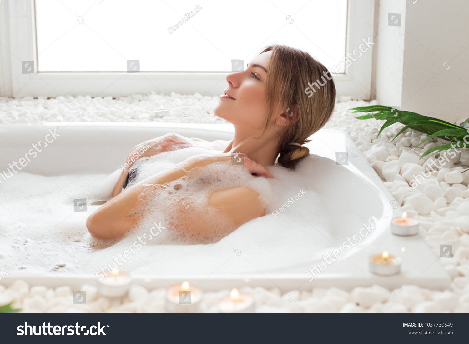 Keep your beauty! Attractively good-looking sexy young girl in bikini lying in soothing bath in ...