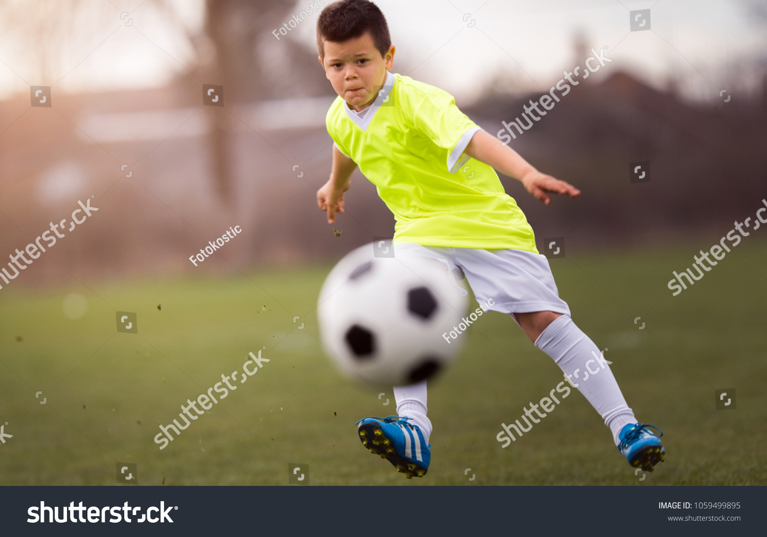 Boy kicking football on the sports field during soccer match_站酷海洛_正版图片 ...