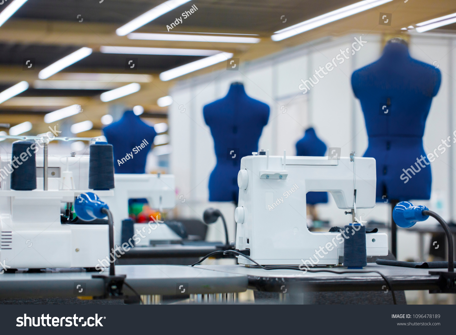 Interior of garment factory . Closes making atelier with several sewing ...