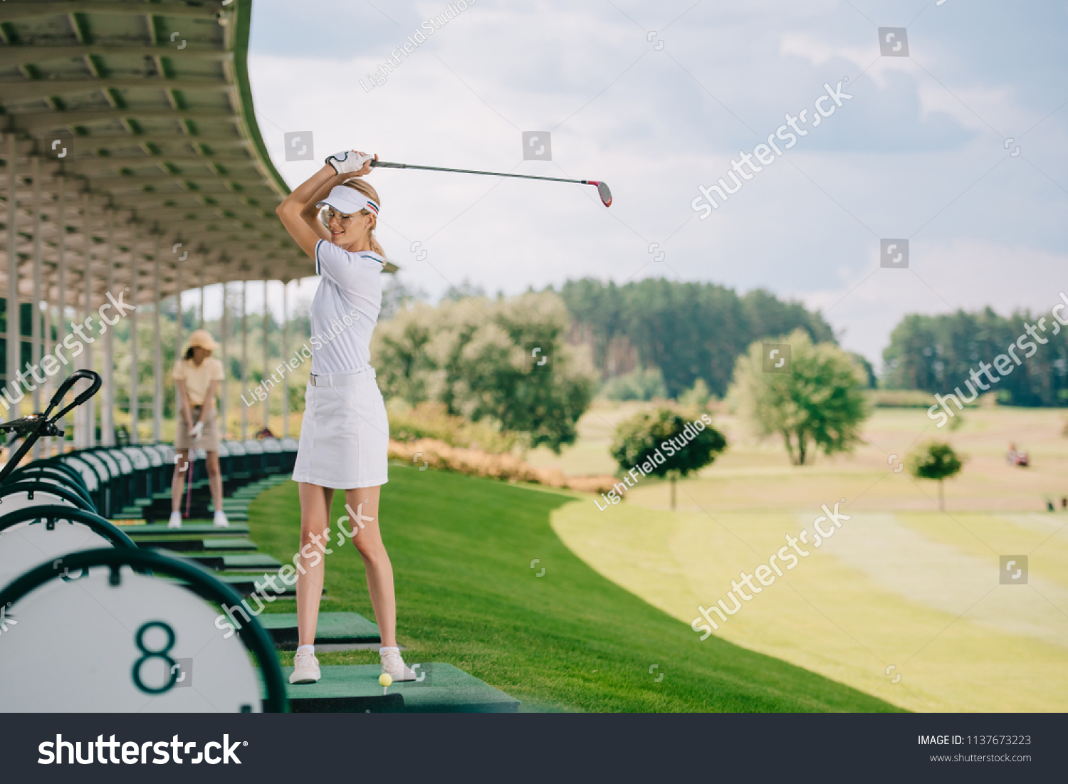 selective focus of smiling female golfer in polo and cap playing golf at golf course_站酷海洛_正版图片 ...