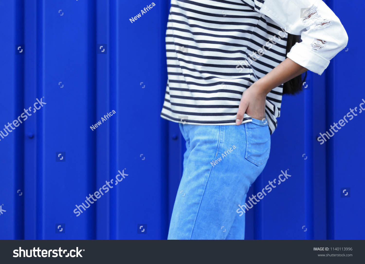Young hipster woman in stylish jeans posing near color wall_站酷海洛_正版图片_视频_字体_音乐素材交易平台_站酷旗下品牌