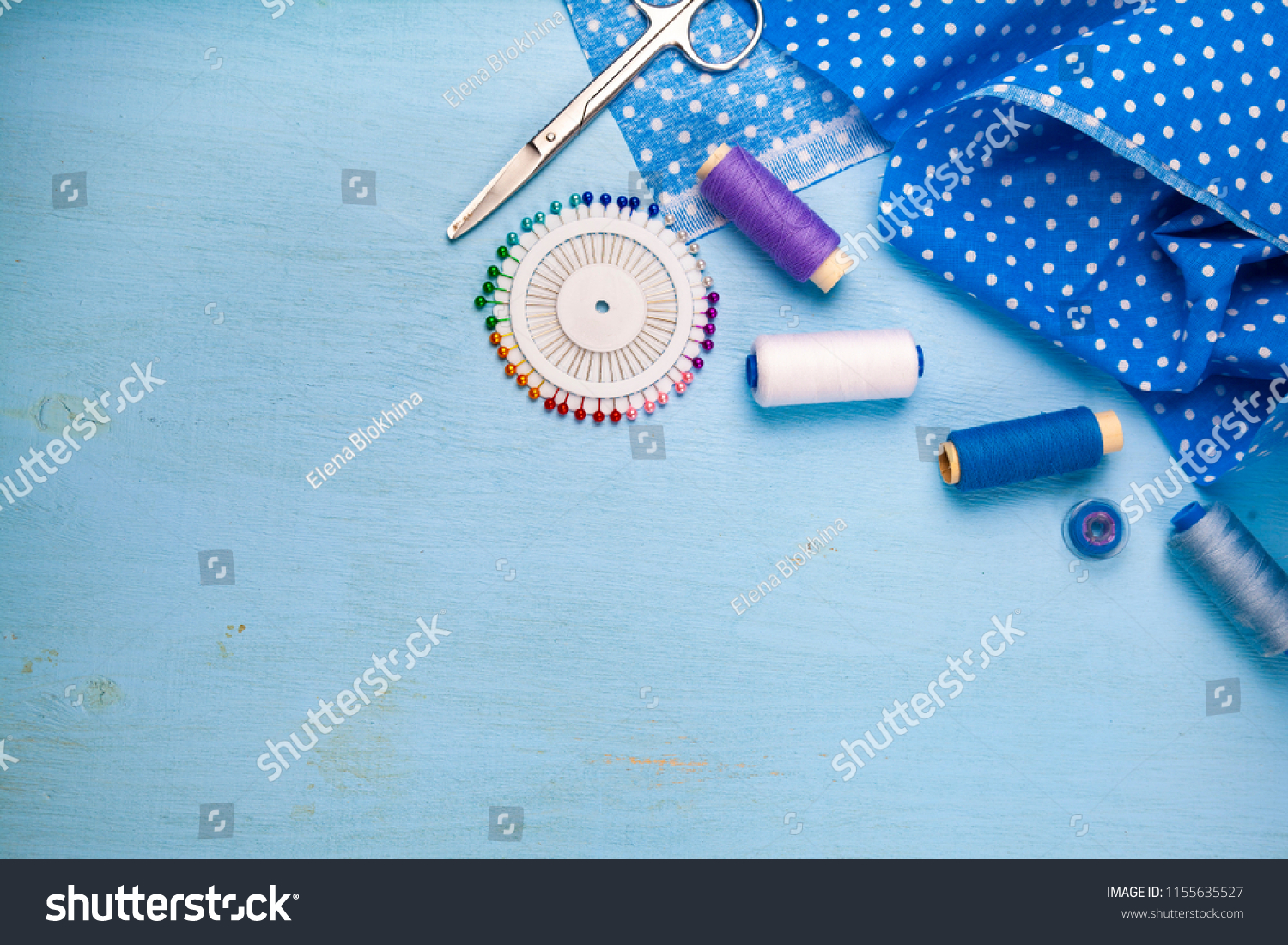 Sewing accessories on a blue wooden background. Blue fabric scissors ...