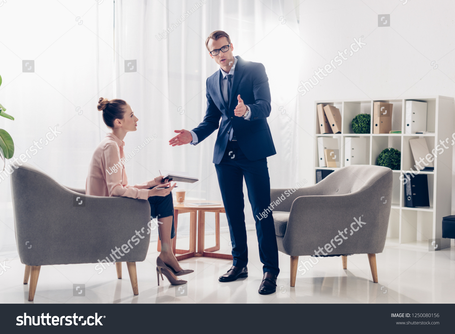 angry businessman standing and gesturing while giving interview to ...