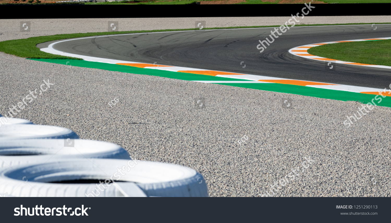 Racing circuit road curve with tyres for protection and orange green ...