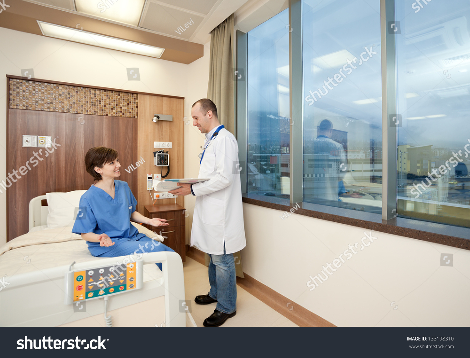 Doctor in medical uniform presenting good news to smiling female ...