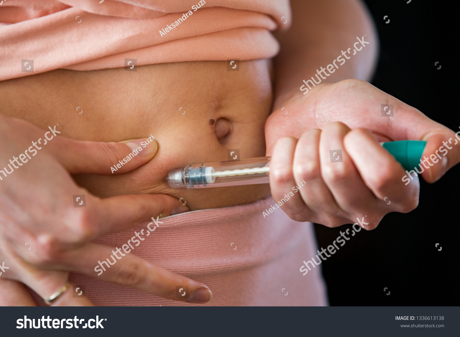 Woman making hormonal therapy injection into her belly. Close up ...