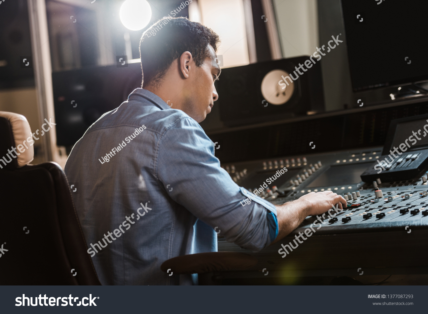 concentrated mixed race sound producer working at mixing console_站酷海洛 ...