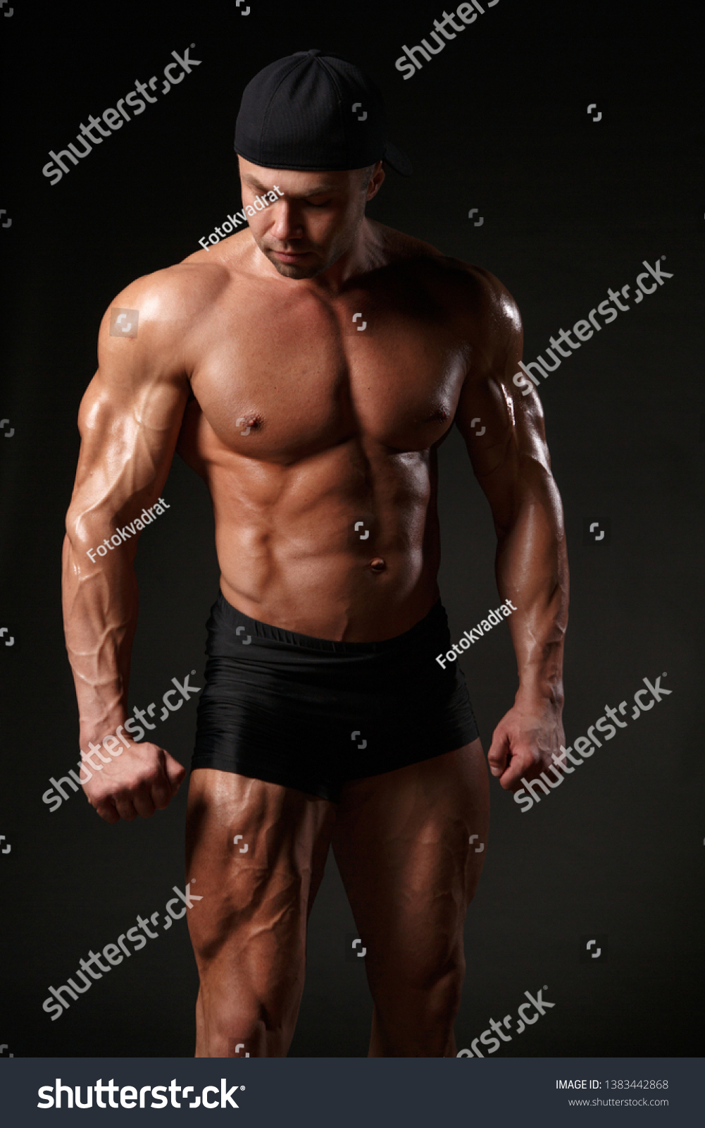 Handsome power athletic man pumping up muscles. Strong bodybuilder with perfect shape body and ...