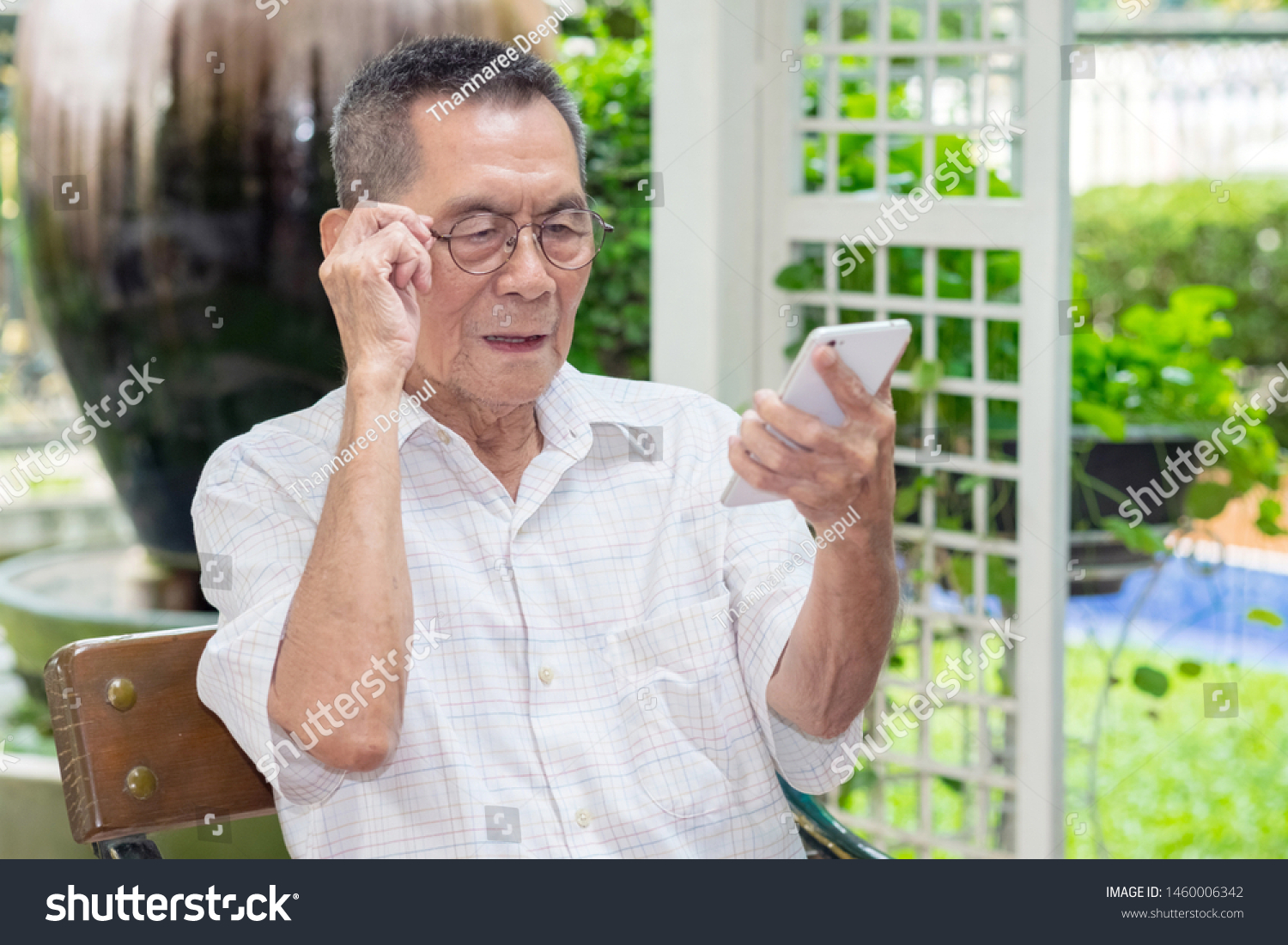 Happy Elderly asian old man hold eye glasses and looking smartphone at outdoor._站酷海洛_正版图片_视频_字体 ...
