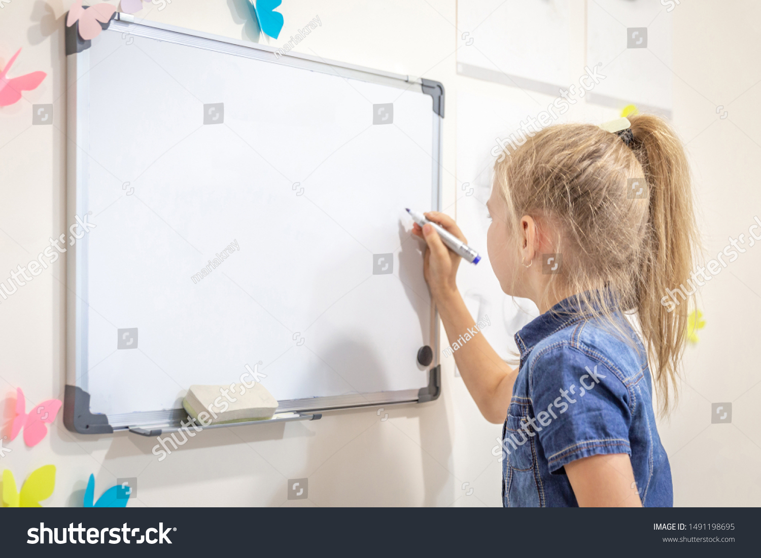 Little girl writing on empty whiteboard with a marker pen. Learning ...