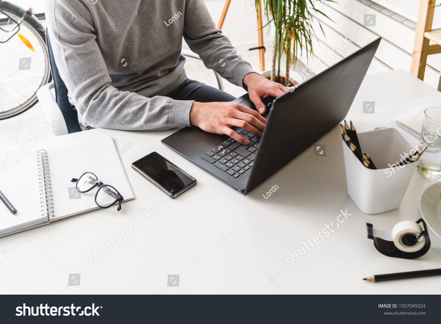 Man using laptop computer while sitting at desk in office. Close-up ...
