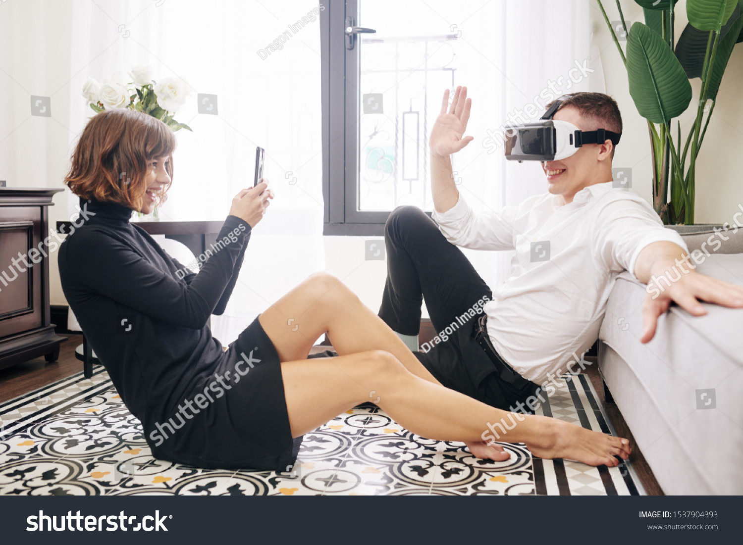 Laughing pretty young woman photographing her boyfriend wearing virtual reality headset_站酷海洛_正版 ...