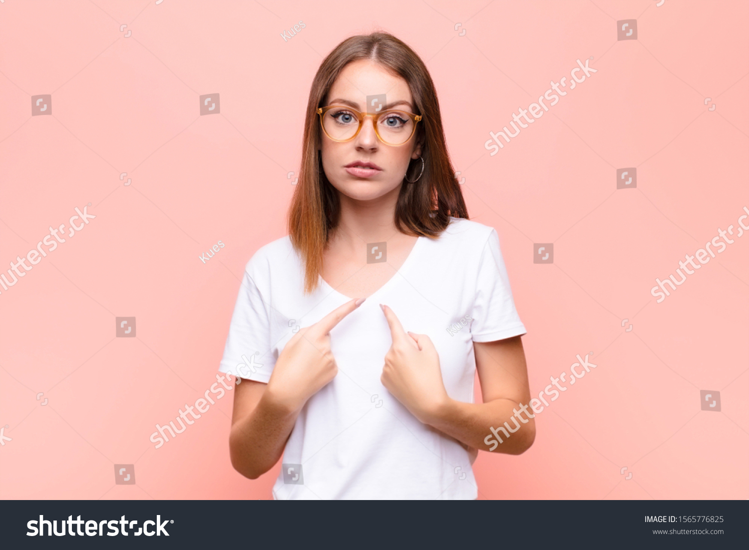 young red head woman pointing to self with a confused and quizzical ...