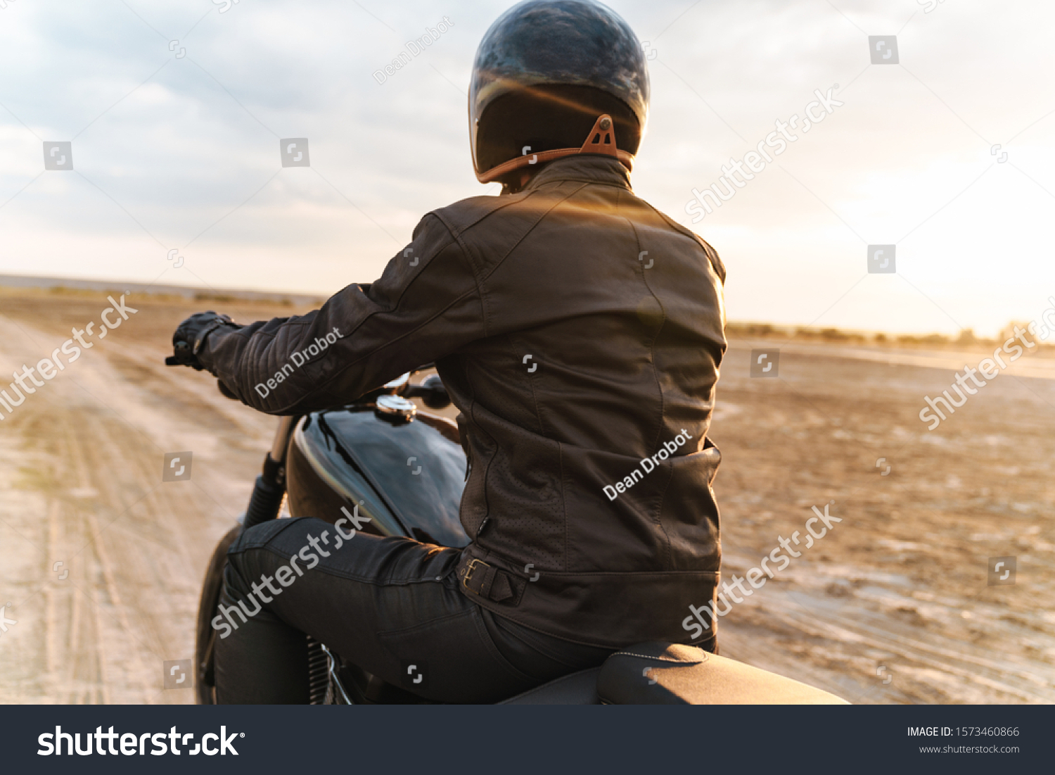 Back view photo of handsome young man biker on bike outdoors at the ...