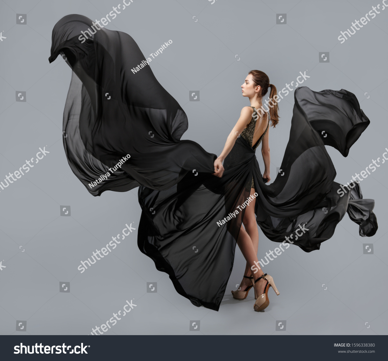 beautiful young girl in flying black dress. Flowing fabric. Light black ...
