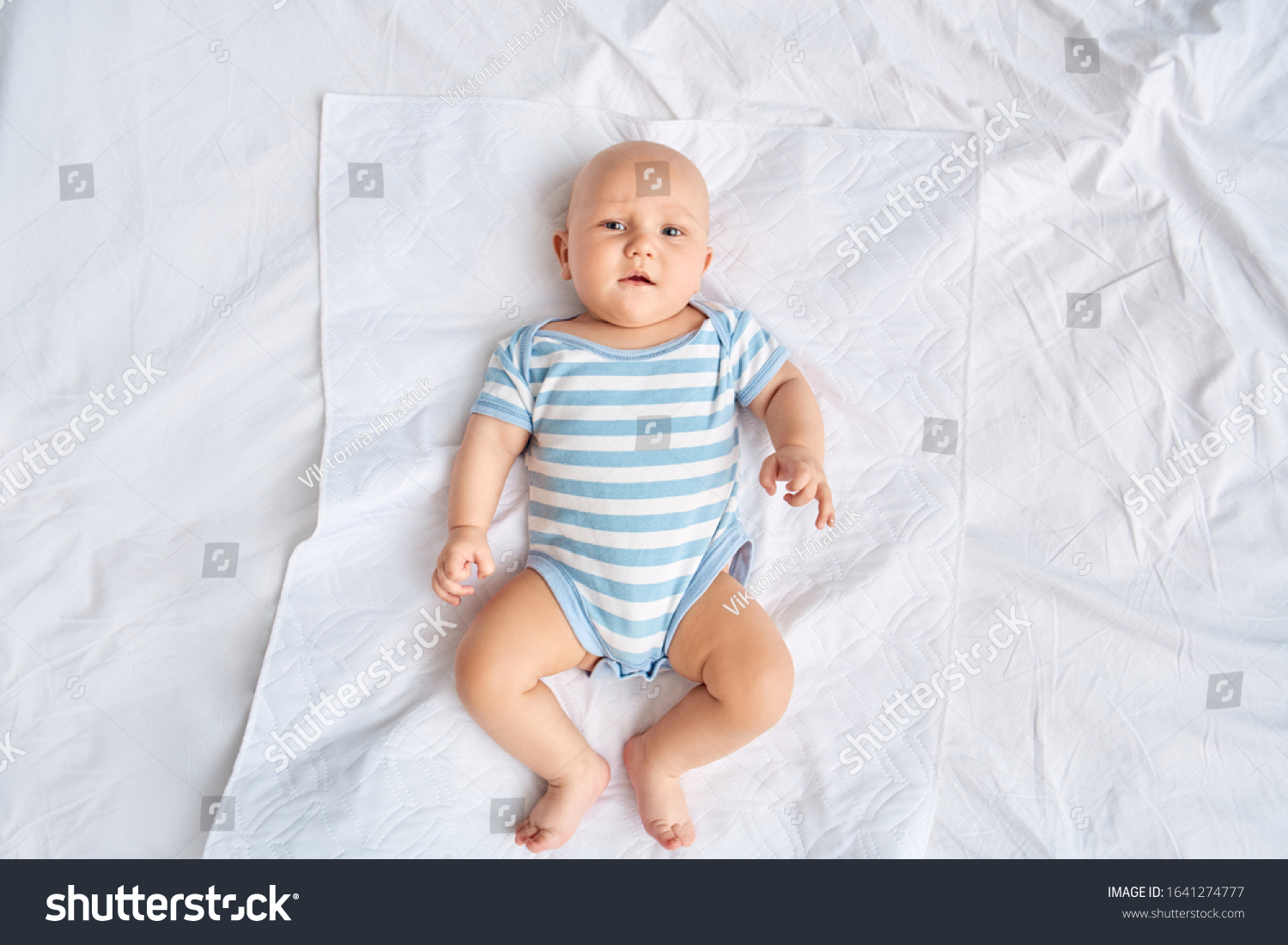 High angle view of cute little new born baby in body wear lying in ...