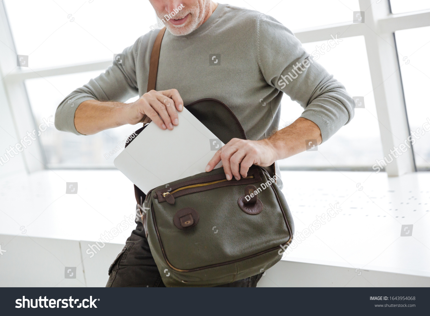 Cropped image of a senior grey-haired bearded businessman indoors put ...