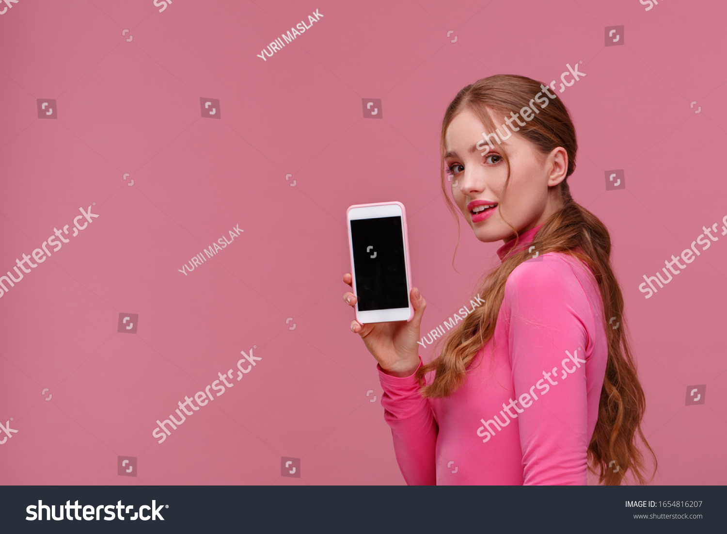 Funny redhead girl showing blank screen mobile phone on camera. Young ...
