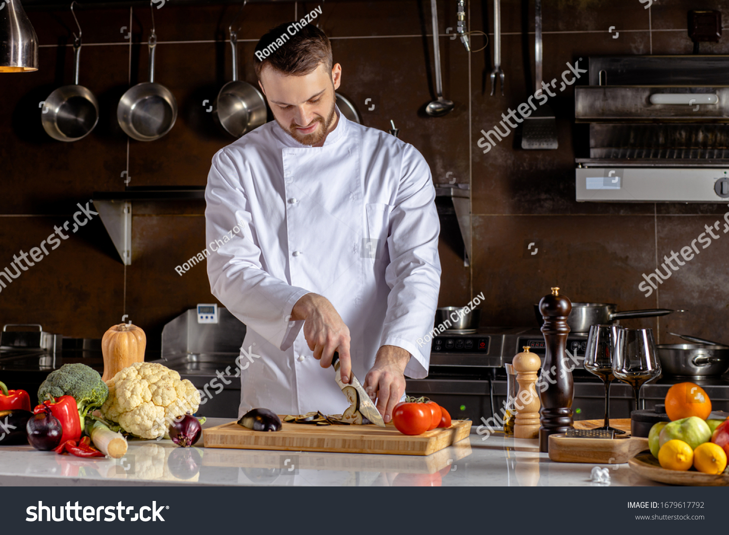 young caucasian chef-cooker cutting fresh vegetables in kitchen. restaurant dish cooking concept ...