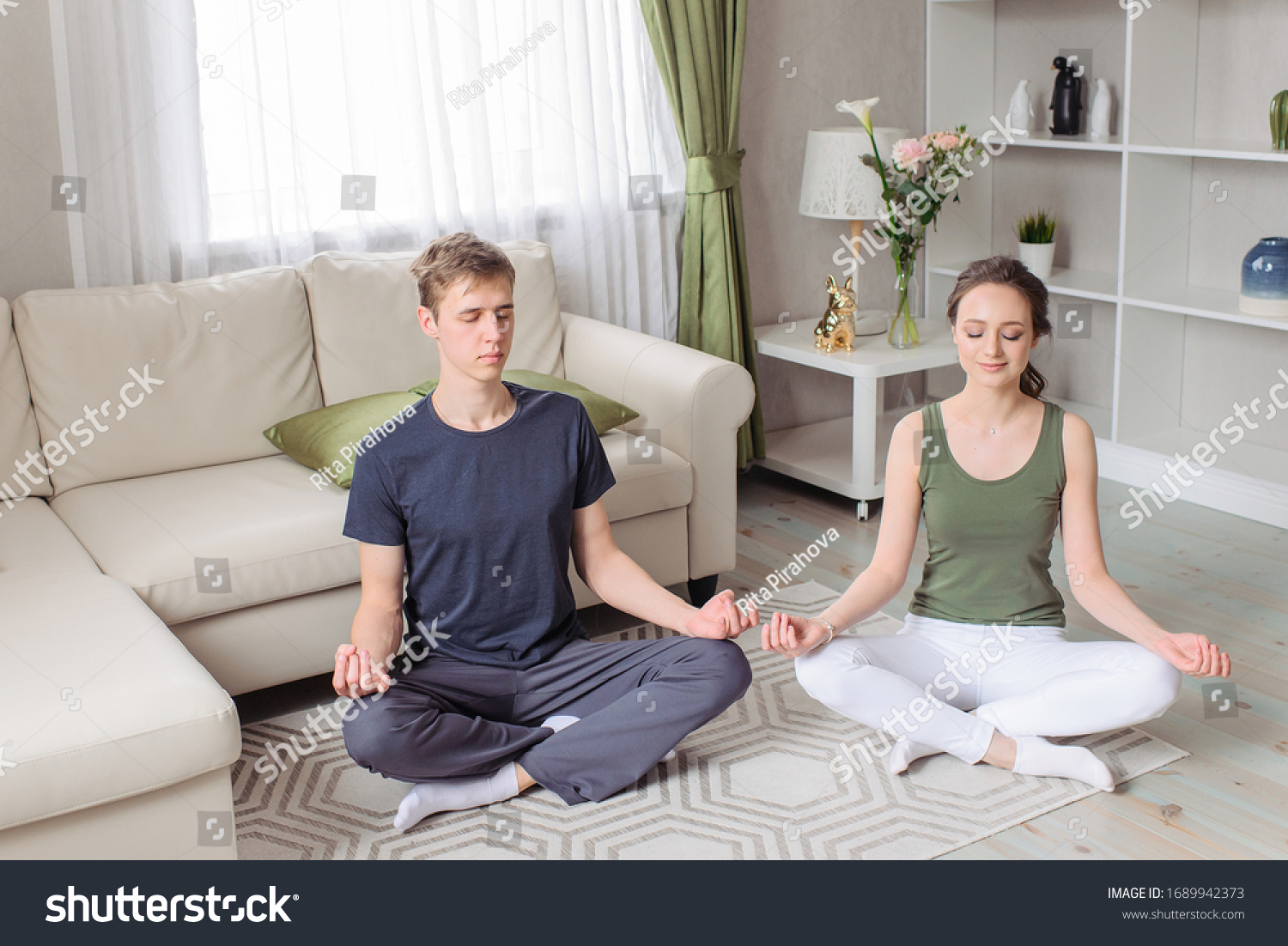 Young couple - man and woman - does sports at home. Sporting wear. Yoga ...