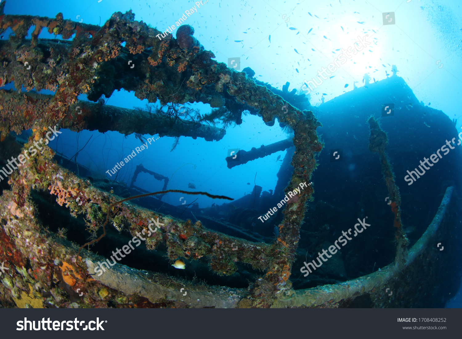 Sunken shipwreck standing upright deep in the turquoise waters of the Caribbean Sea underneath ...