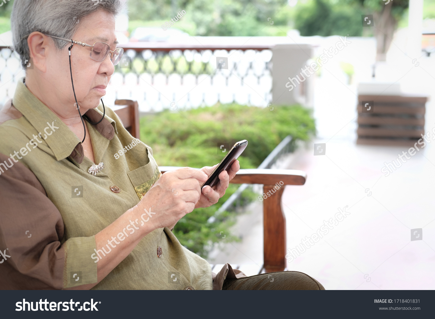 elder woman holding mobile phone. elderly senior female texting message using app with ...