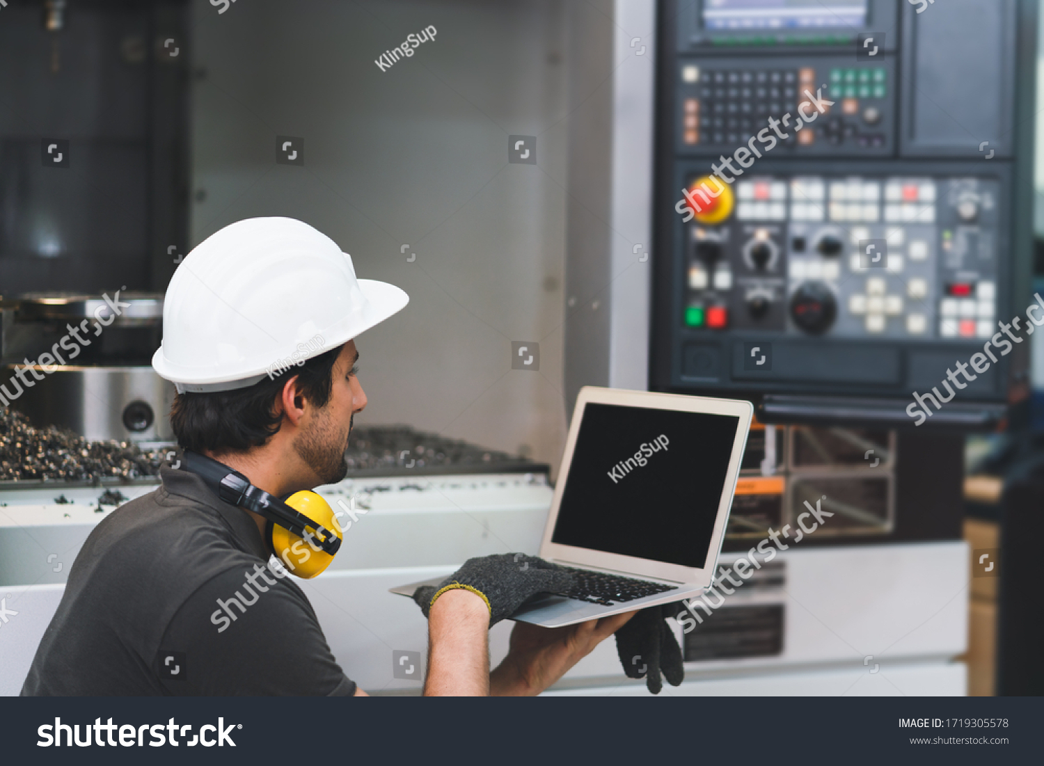 Engineer using laptop computer operating control CNC Machinery at ...