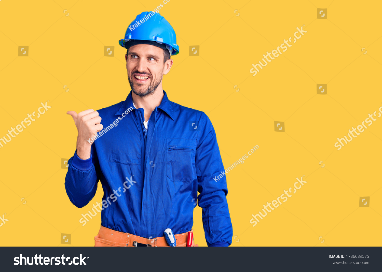 Young handsome man wearing worker uniform and hardhat smiling with ...