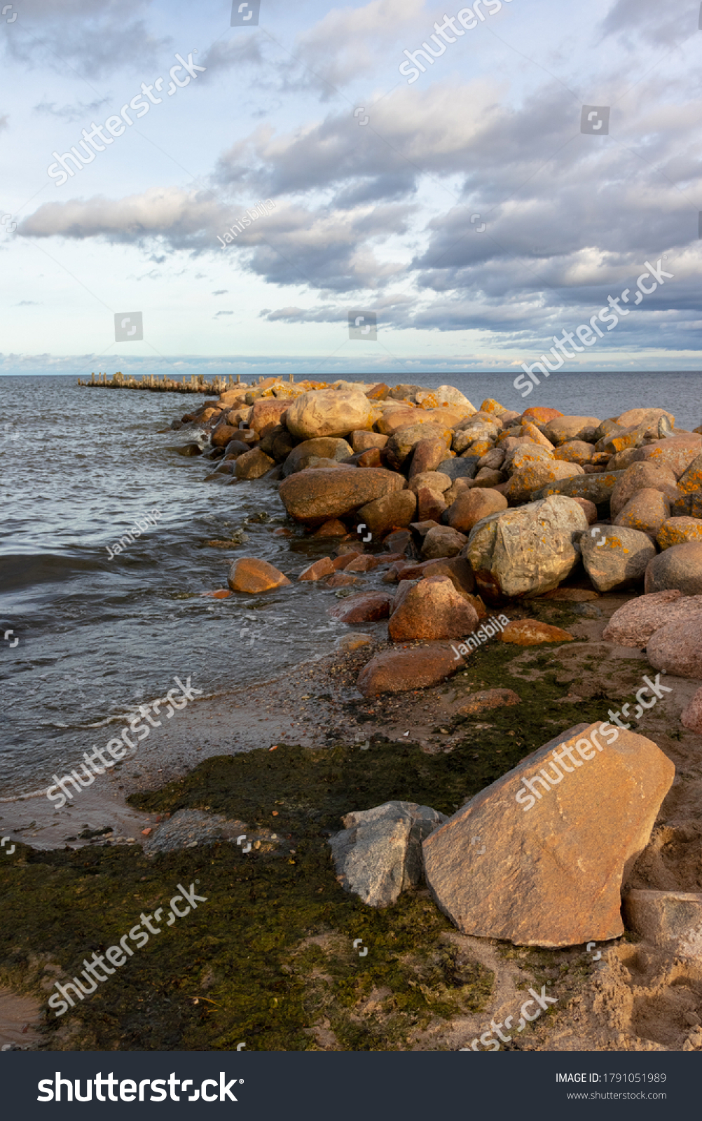 An old sea port mole built of large boulders. Beautiful sky with ...