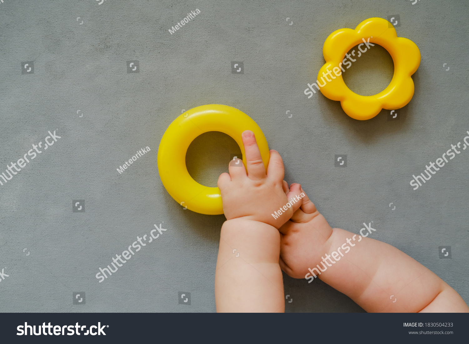 Baby hands and plastic developing toys. Overhead view. Baby goods ...