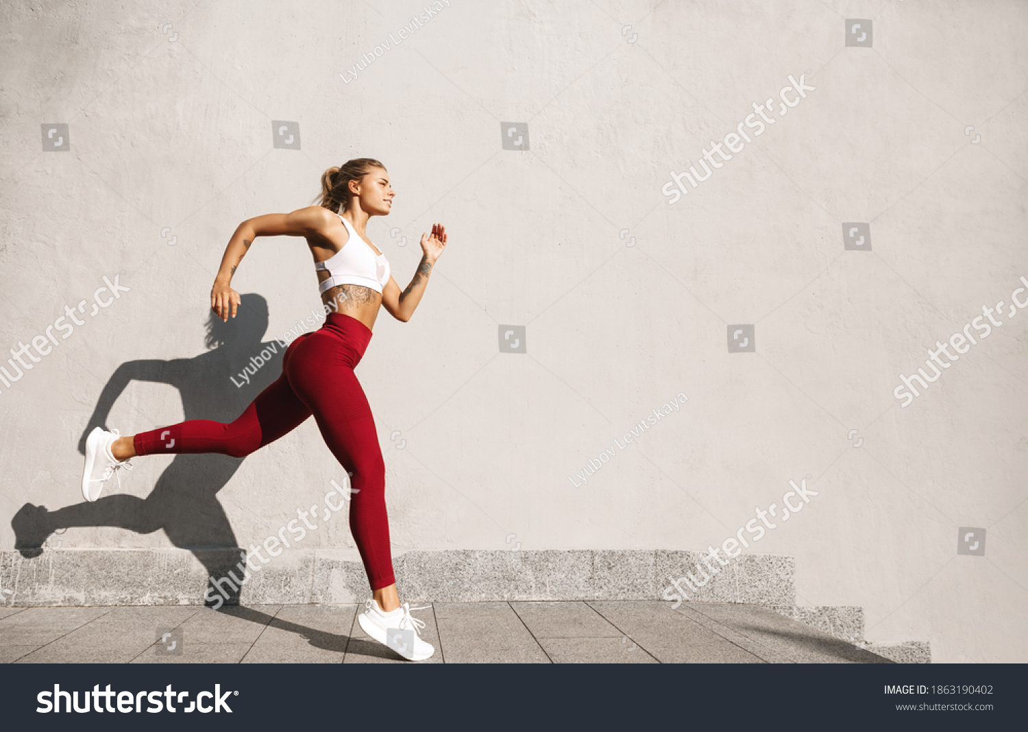 Strong woman in sportswear running and exercising outdoors. Caucasian ...