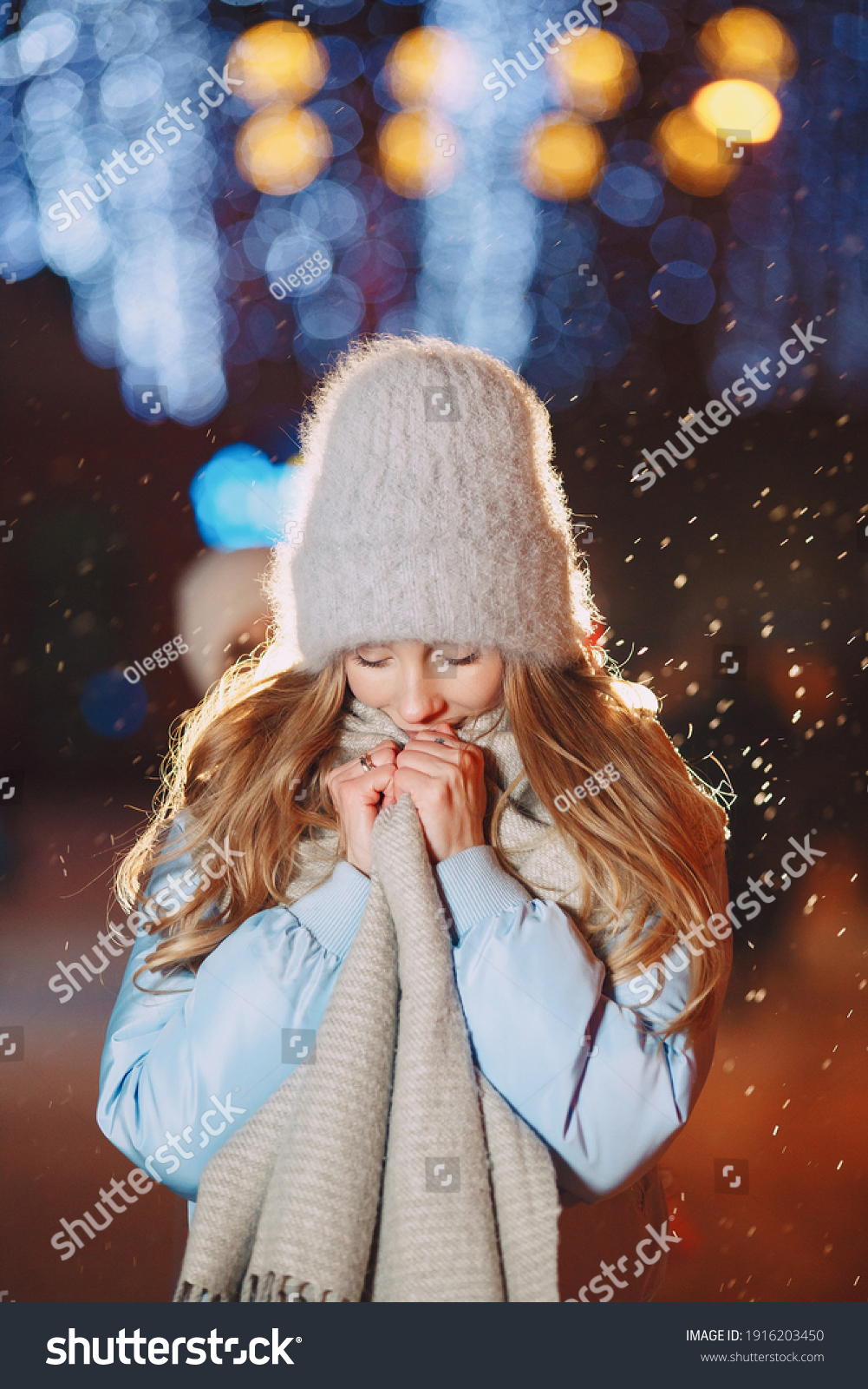 Winter holidays conception. Outdoor night portrait of young girl. Posing in street of European ...