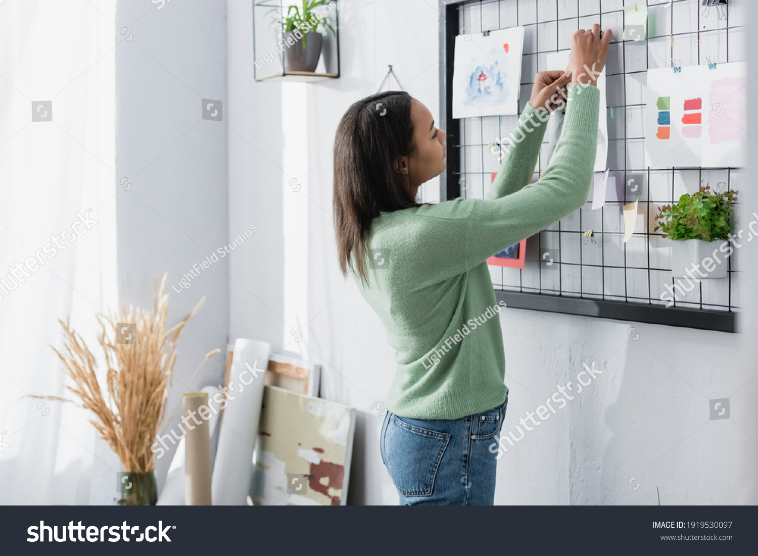african american interior designer fixing painting on wall at home_站酷海洛 ...
