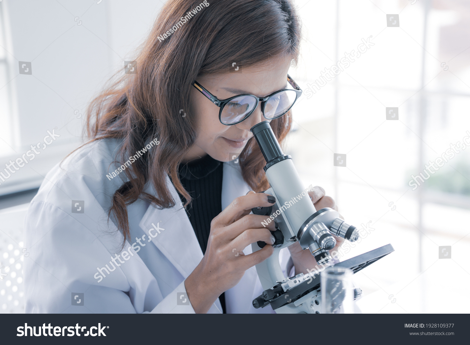 Asian female scientist wearing eyeglasses is researching using ...