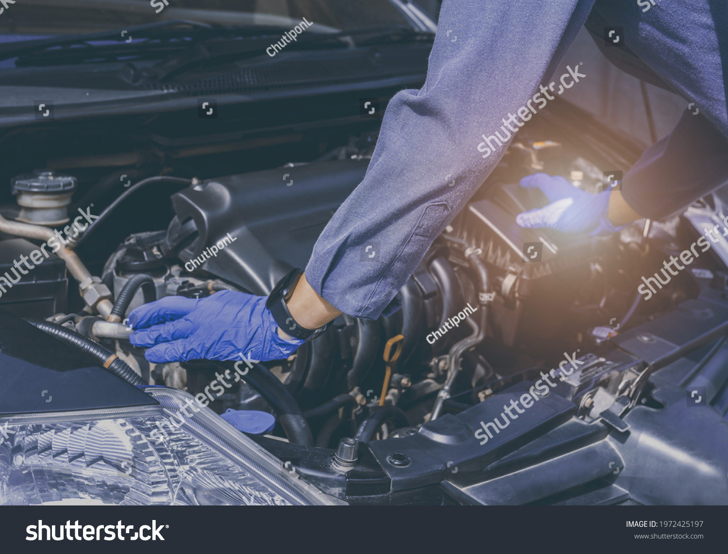 Automobile mechanic repairman hands repairing a car engine automotive ...