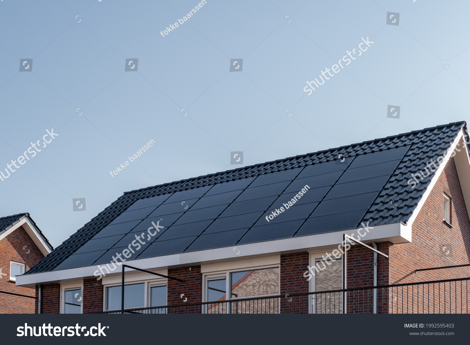 Newly build houses with solar panels attached on the roof against a ...