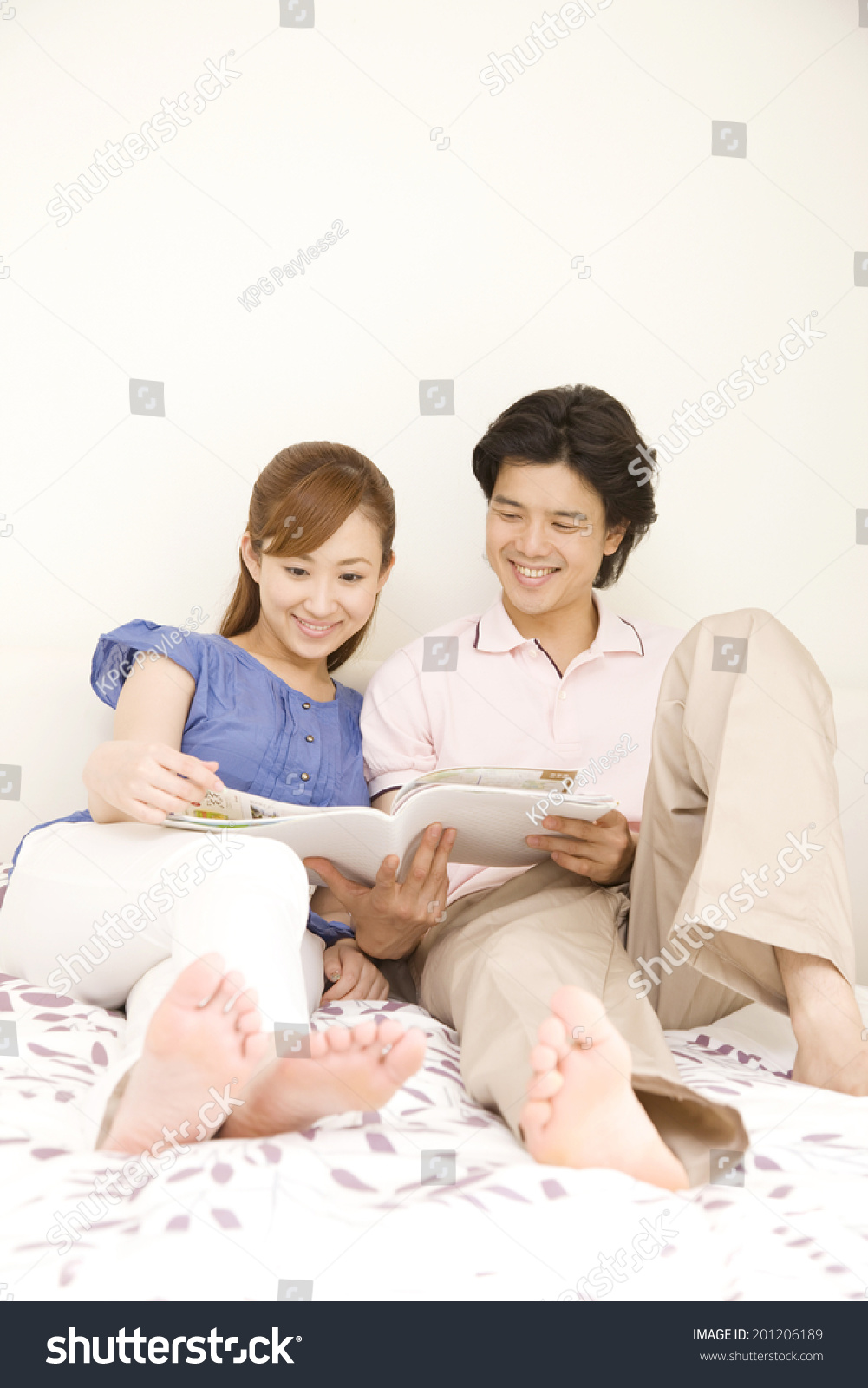 The man and woman reading magazines on the bed_站酷海洛_正版图片_视频_字体_音乐素材交易平台_站酷旗下品牌