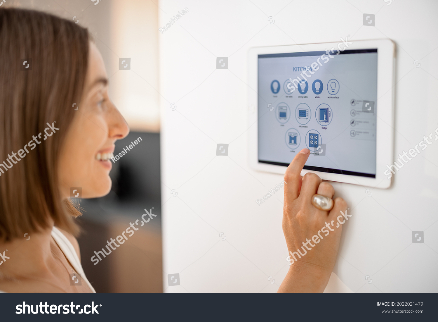 Happy woman controlling smart devices using control panel mounted on ...
