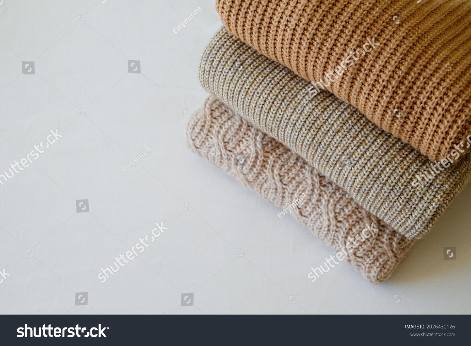 Bunch of knitted warm pastel color sweaters with different knitting ...