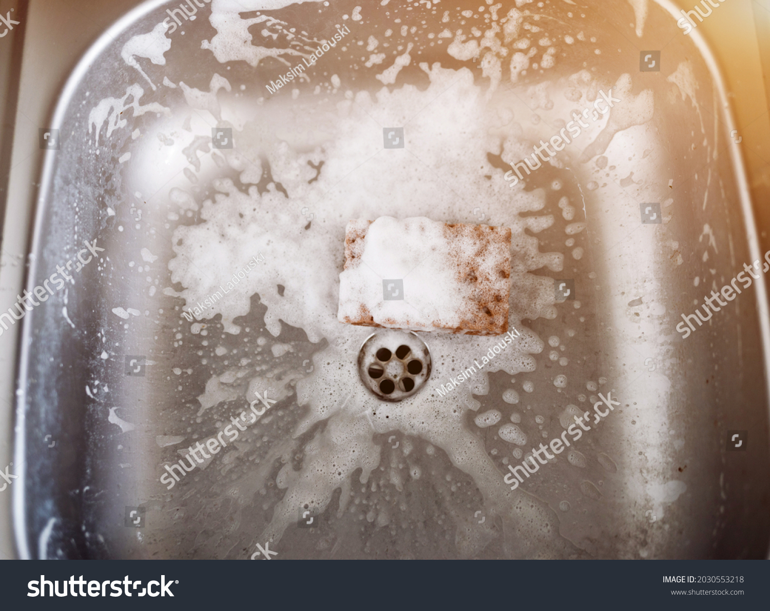 Close up sink drain and sponge. Cleaning metallic sink housework ...