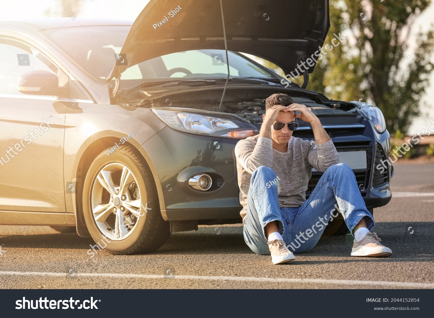 Young man near broken car on road_站酷海洛_正版图片_视频_字体_音乐素材交易平台_站酷旗下品牌