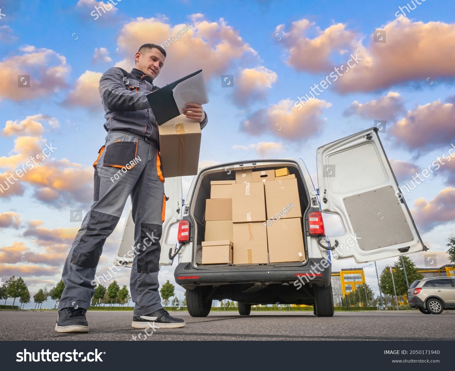 The driver postman draws up documents. Cargo delivery. The van is ...