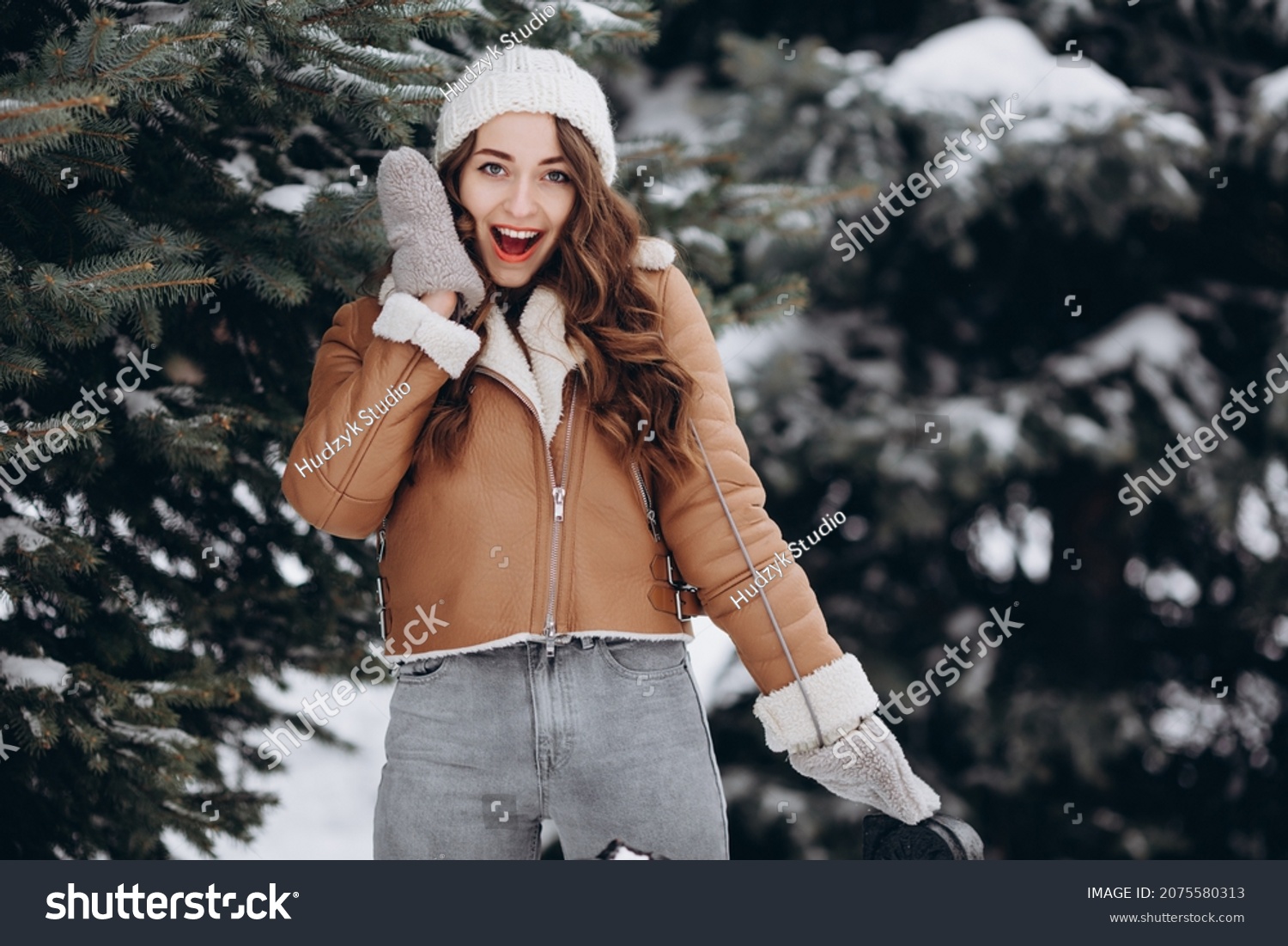Portrait of shocked girl in a winter park wearing a jacket bright jeans ...