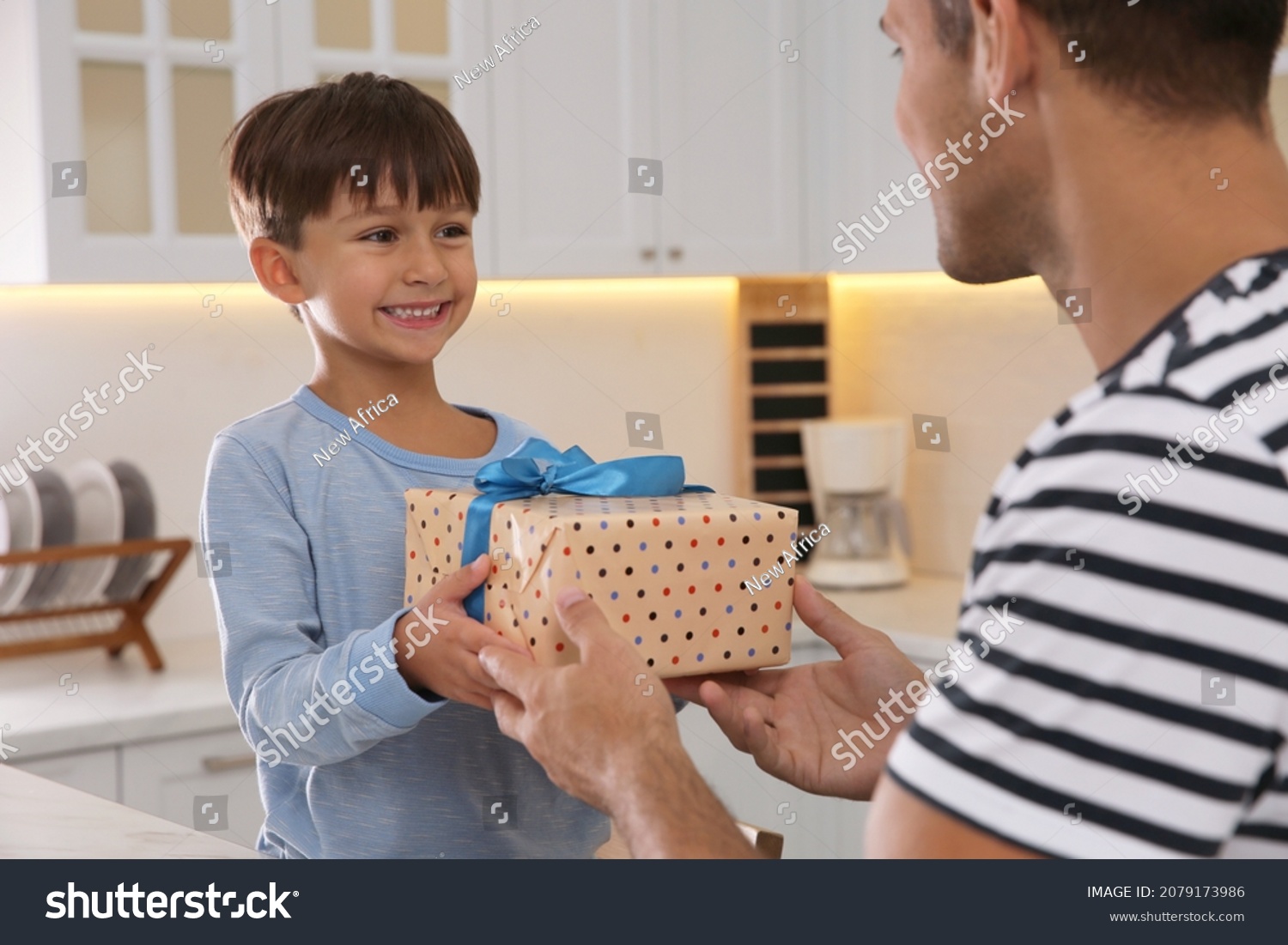 Man receiving gift for Father's Day from his son in kitchen_站酷海洛_正版图片 ...