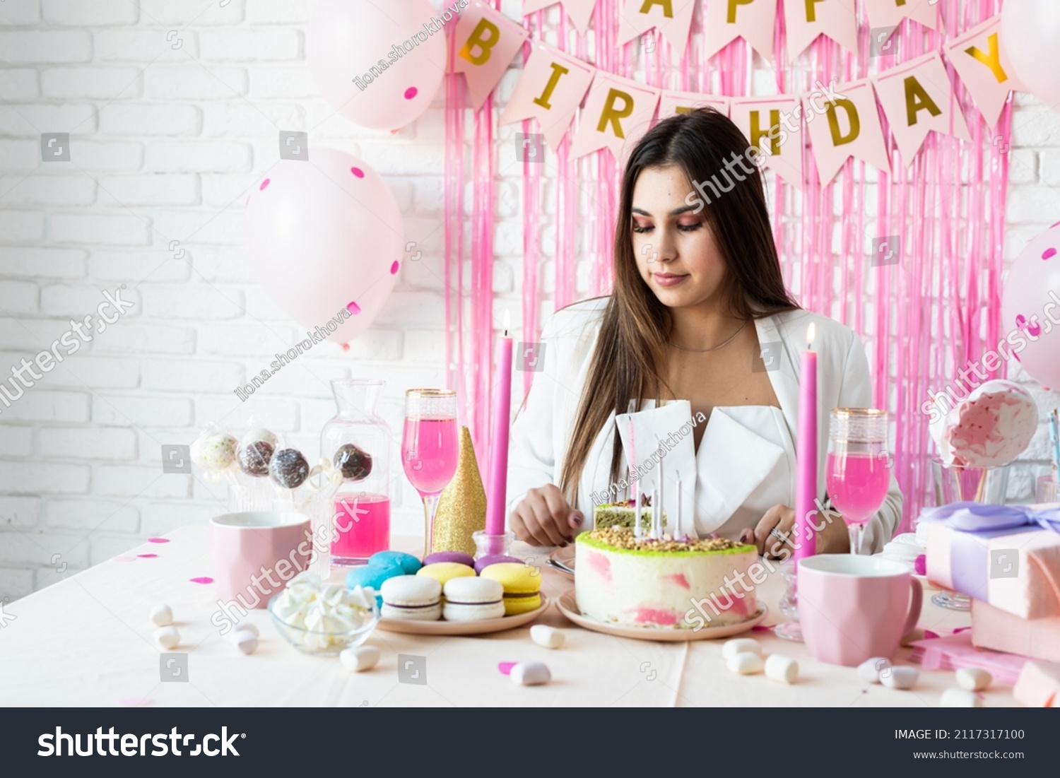 Birthday party. Birthday tables. Attractive brunette woman in white ...