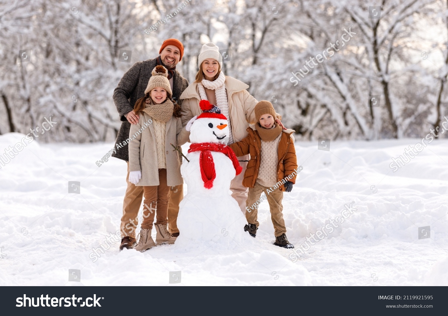 Happy family members dressed in warm clothes laughing merrily while ...