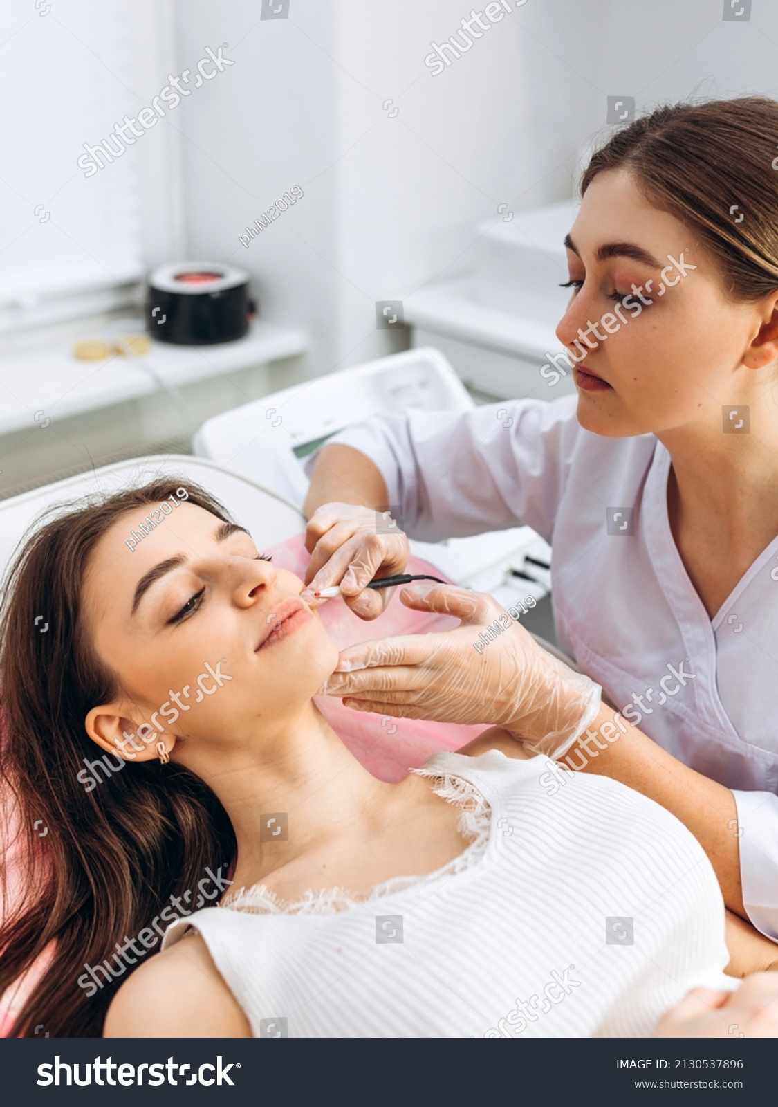 Closeup image of dermatologist's hands doing electro-epilation. The ...