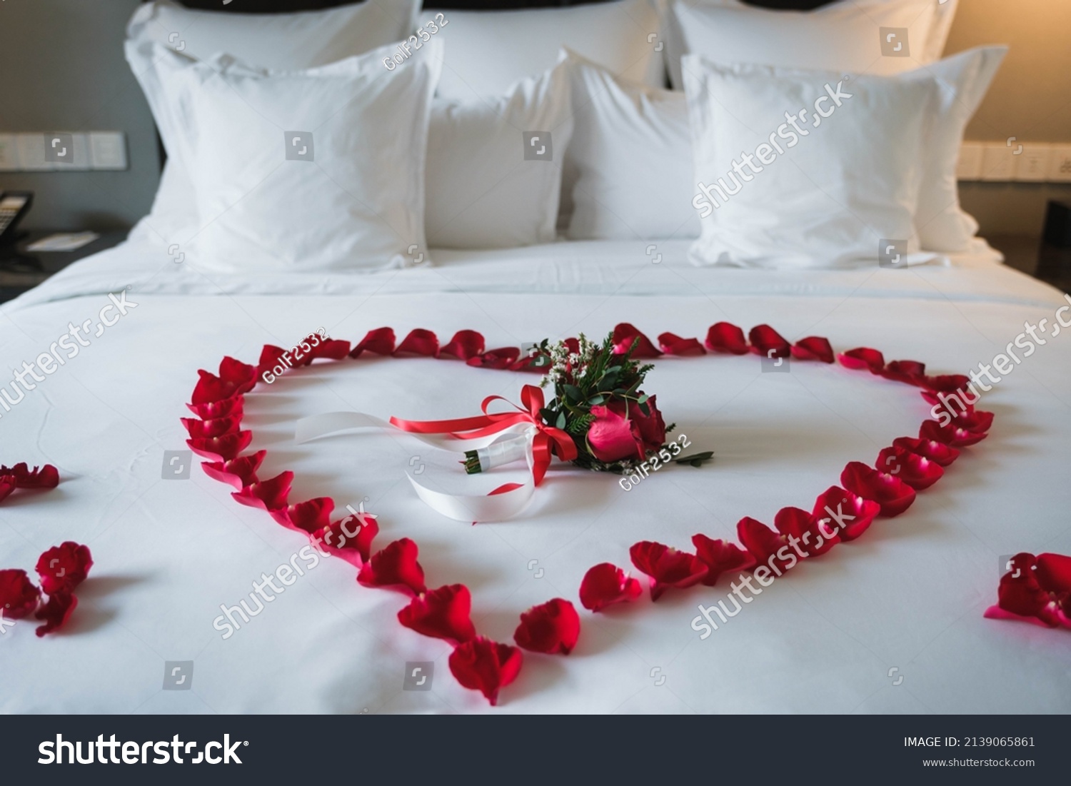 Honeymoon Wedding bed topped with rose petals swain on a special day ...
