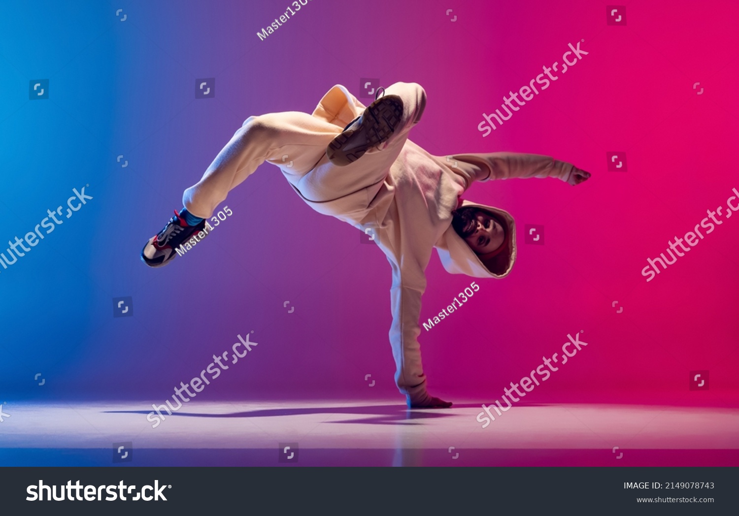 Hand stand. Studio shot of young flexible sportive man dancing ...